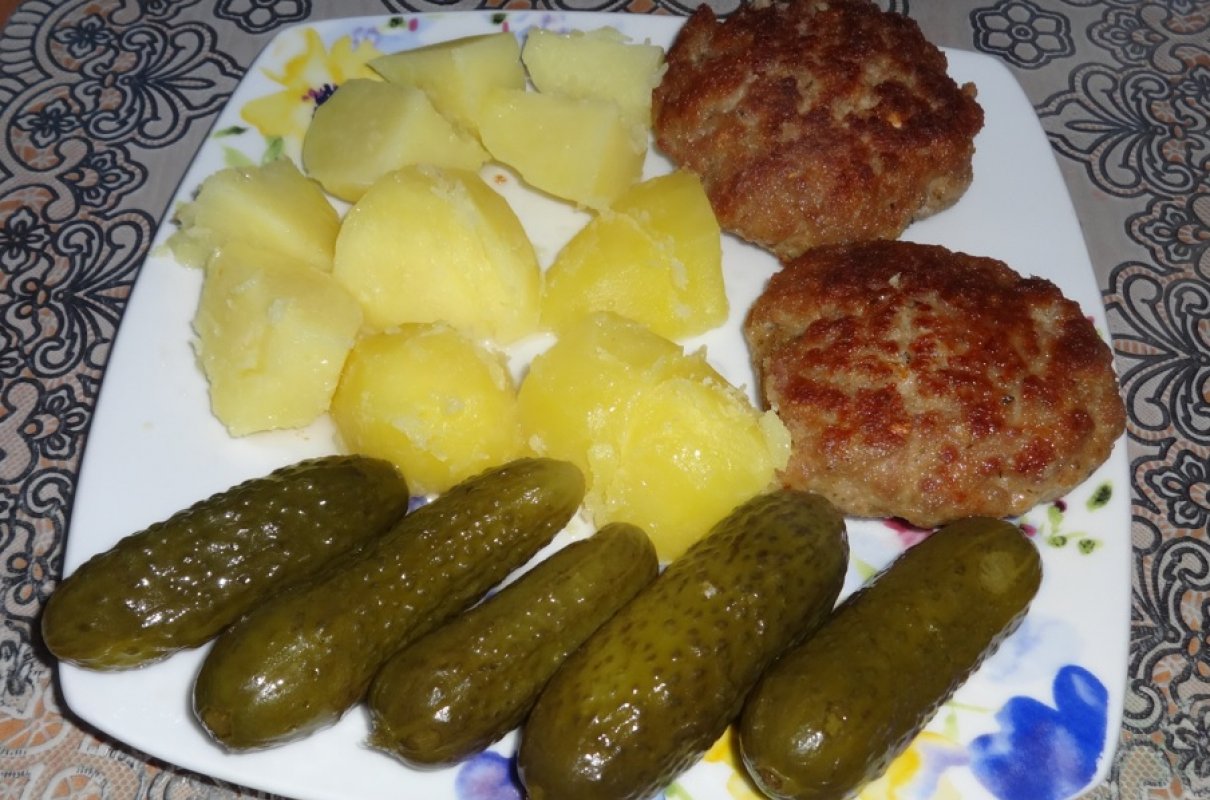 Kotlet mielony, ziemniaki i marynowane ogórki.